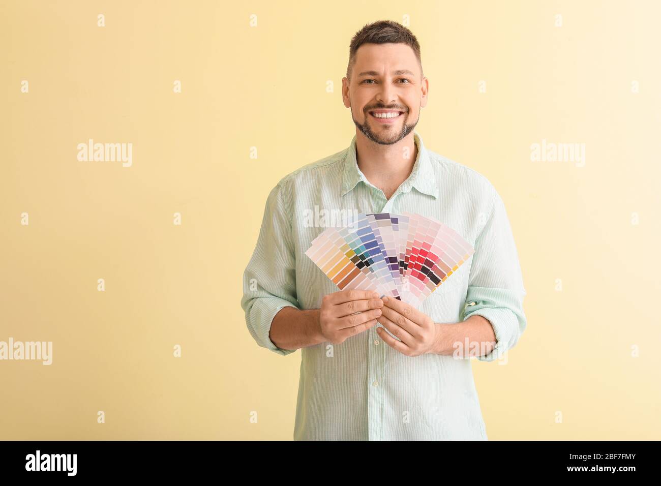Man with color palettes on light background Stock Photo - Alamy