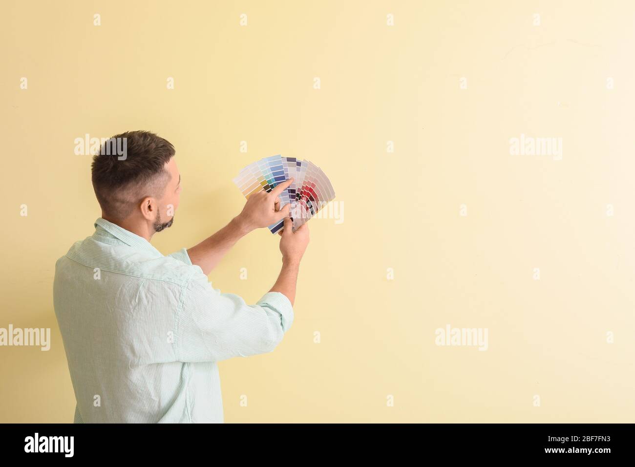 Man with color palettes on light background Stock Photo - Alamy