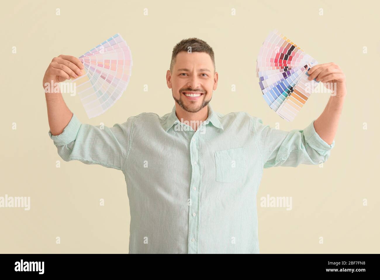 Man with color palettes on light background Stock Photo - Alamy