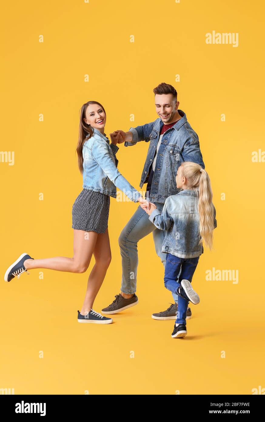 Happy family dancing against color background Stock Photo - Alamy