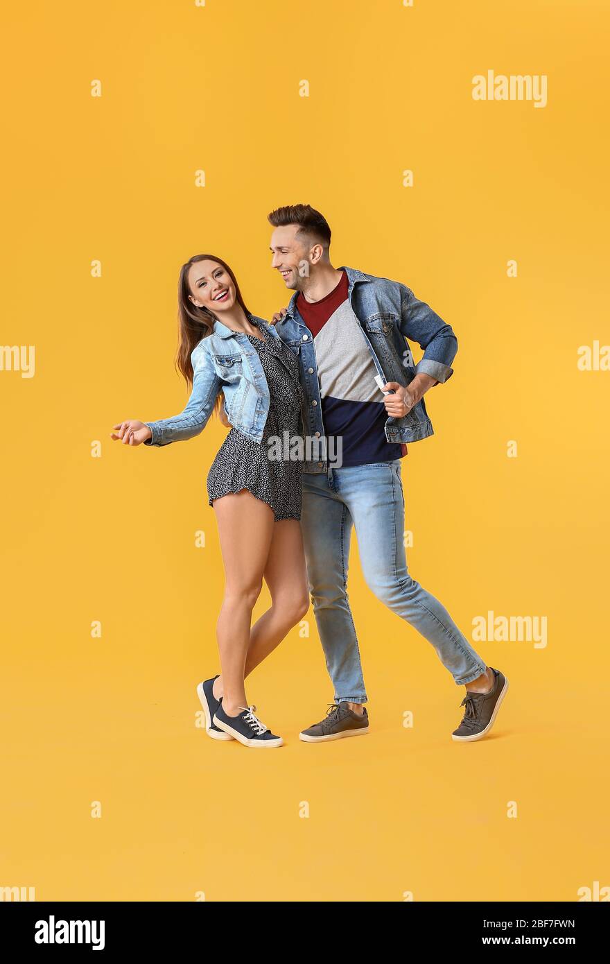 Happy couple dancing against color background Stock Photo - Alamy