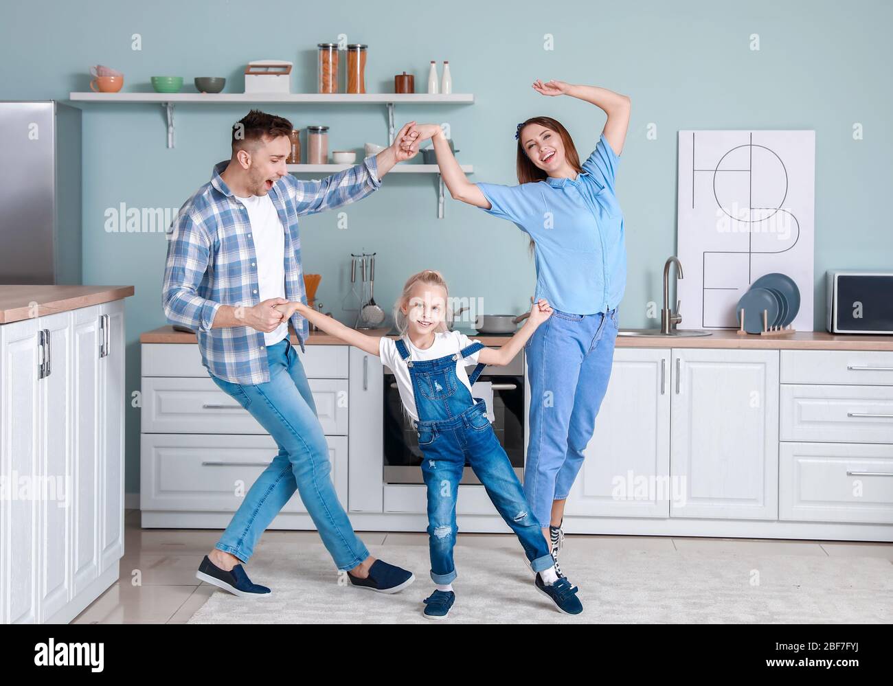 Happy family dancing in kitchen Stock Photo - Alamy