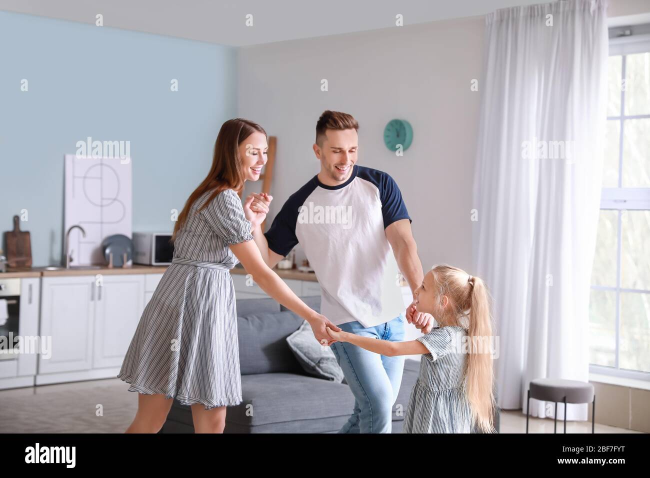 Happy family dancing in kitchen Stock Photo - Alamy