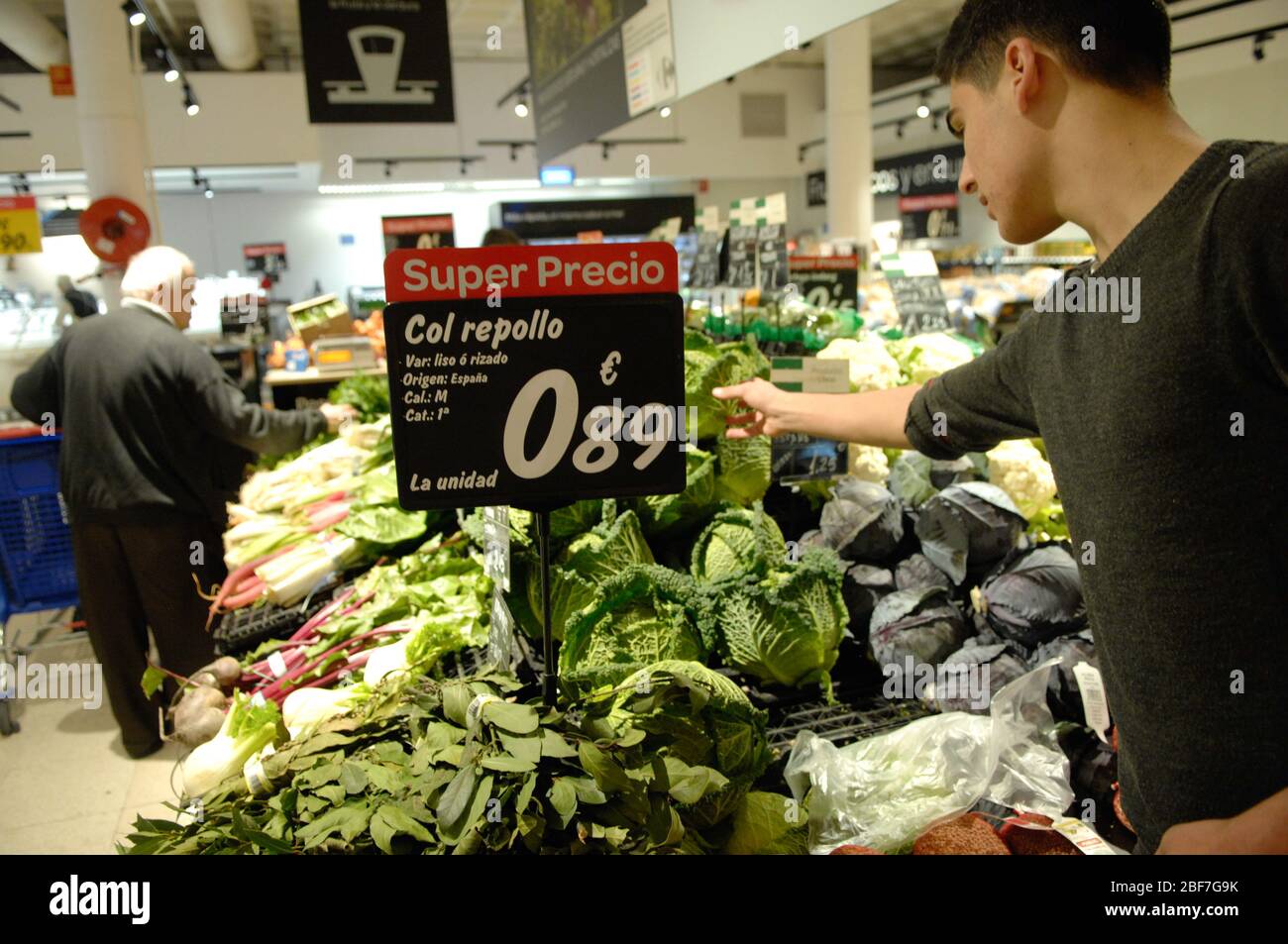 a boy picking up a cabbage in Supermarket Stock Photo - Alamy