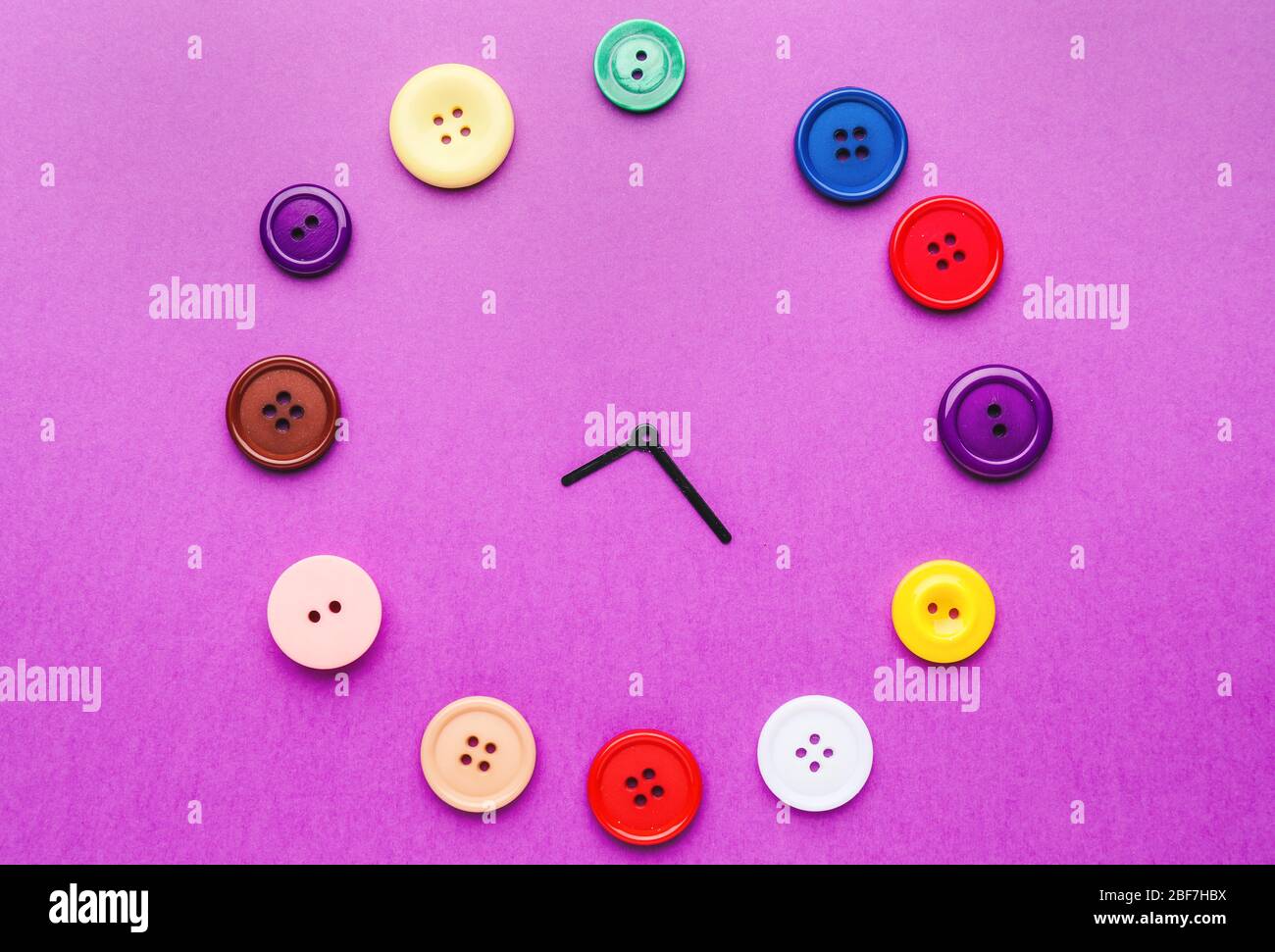 Creative clock made with buttons on color background Stock Photo - Alamy