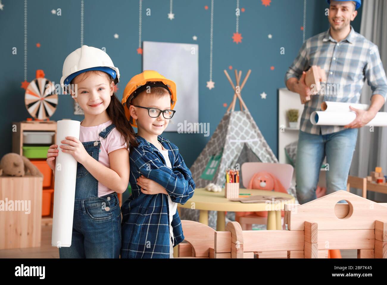 Little children dressed as builders playing with take-apart house at ...