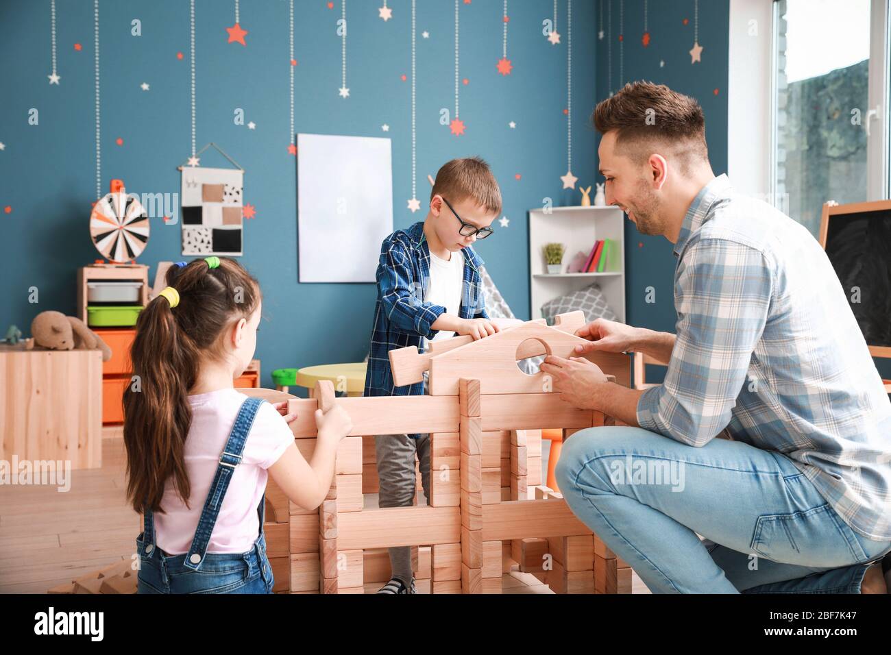Father and little children playing with take-apart house at home Stock ...