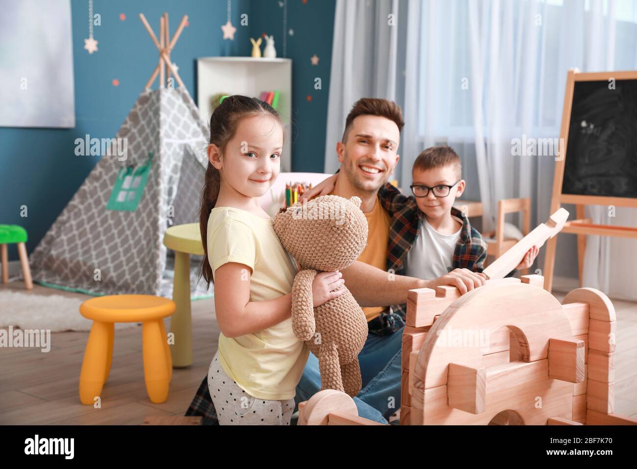 Father and little children playing with take-apart house at home Stock ...