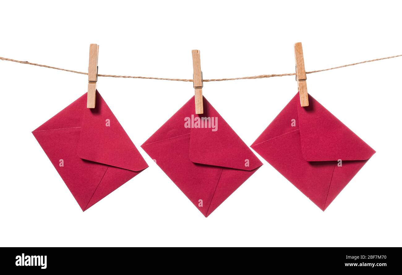 Paper envelopes hanging on rope against white background Stock Photo ...