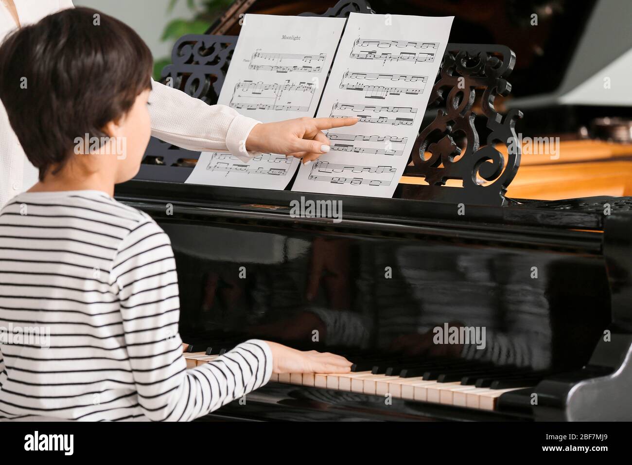 Private music teacher giving piano lessons to little boy Stock Photo ...
