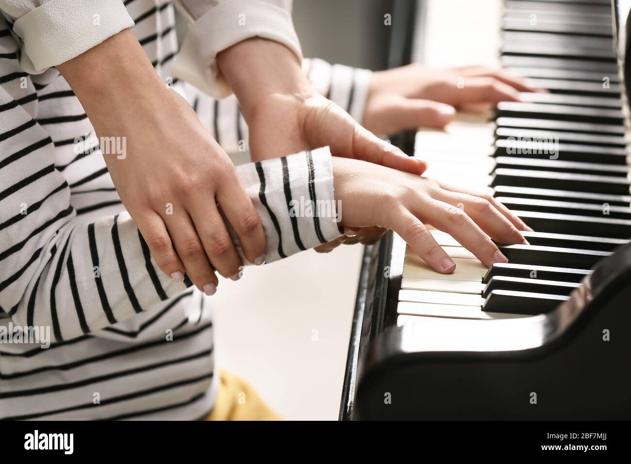 Private music teacher giving piano lessons to little boy, closeup Stock ...