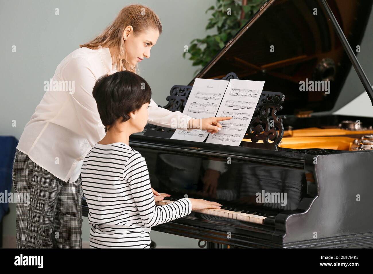 Private music teacher giving piano lessons to little boy Stock Photo ...