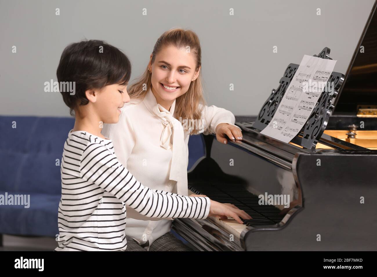Private music teacher giving piano lessons to little boy Stock Photo ...