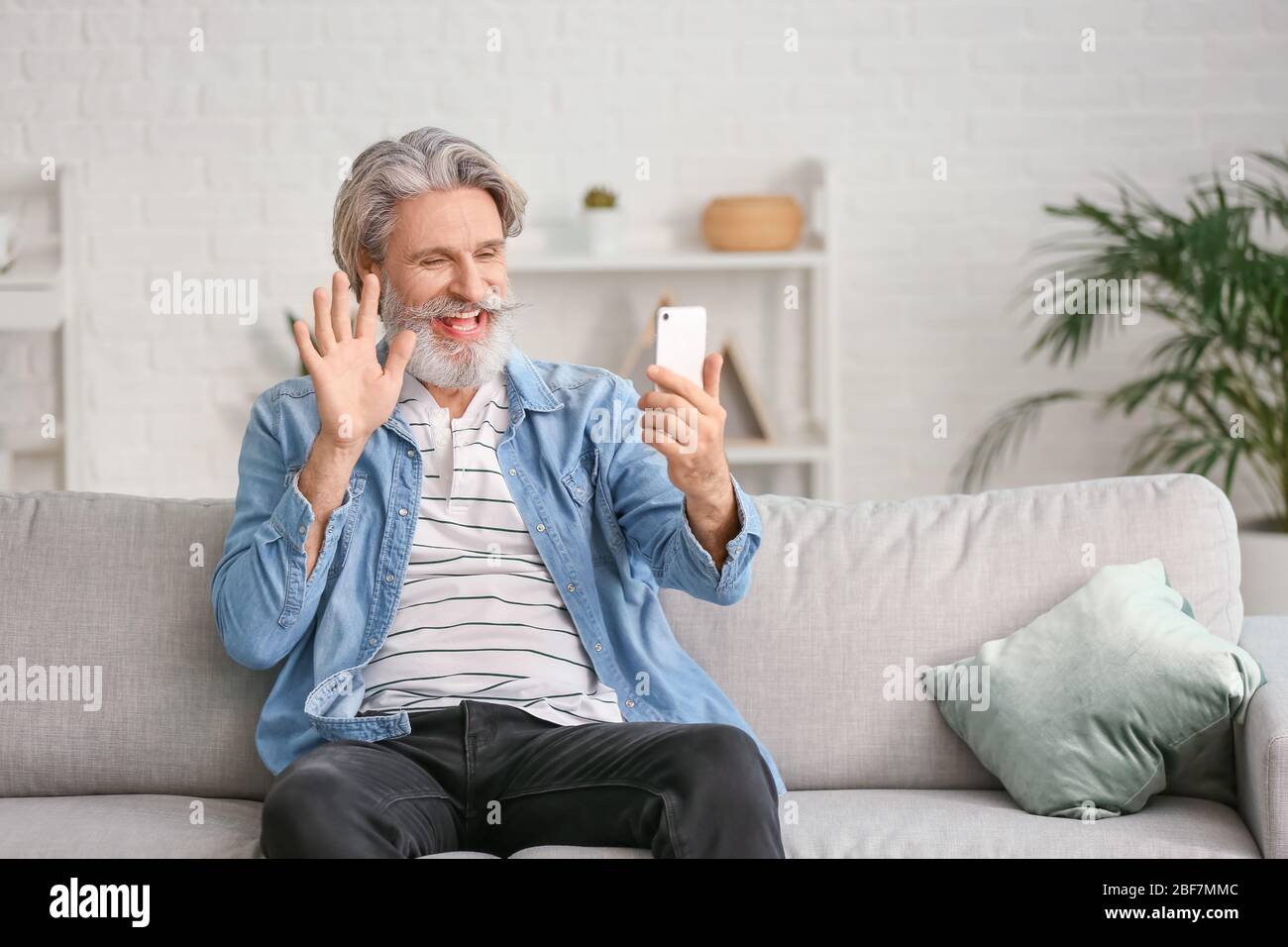 Happy elderly man with mobile phone at home Stock Photo - Alamy