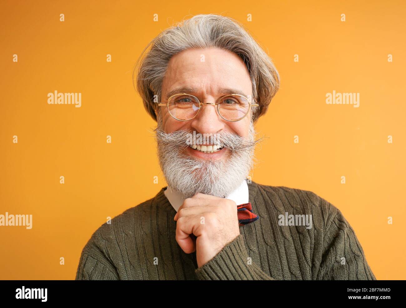 Stylish elderly man on color background Stock Photo - Alamy