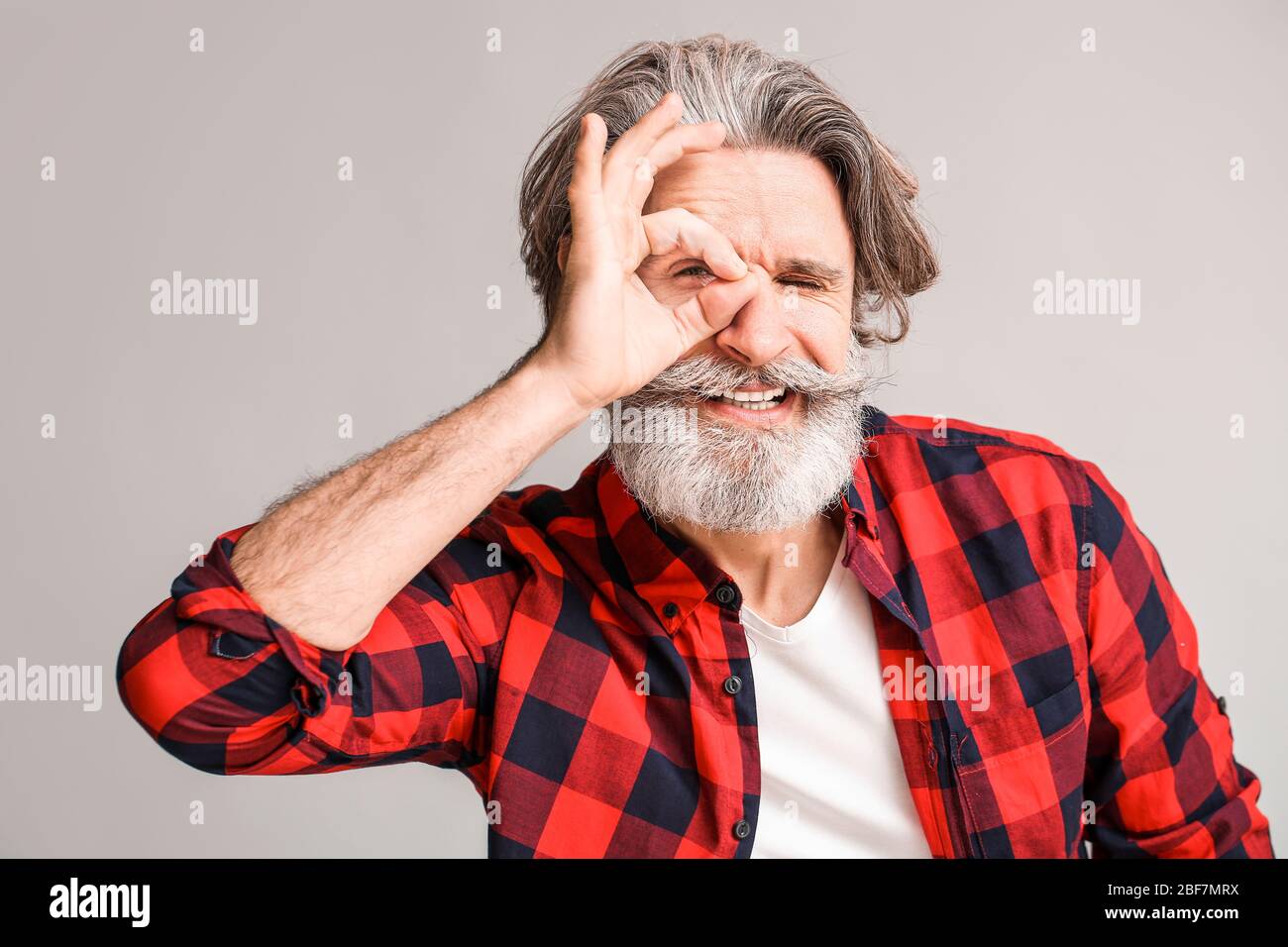 Stylish elderly man showing OK gesture on grey background Stock Photo ...