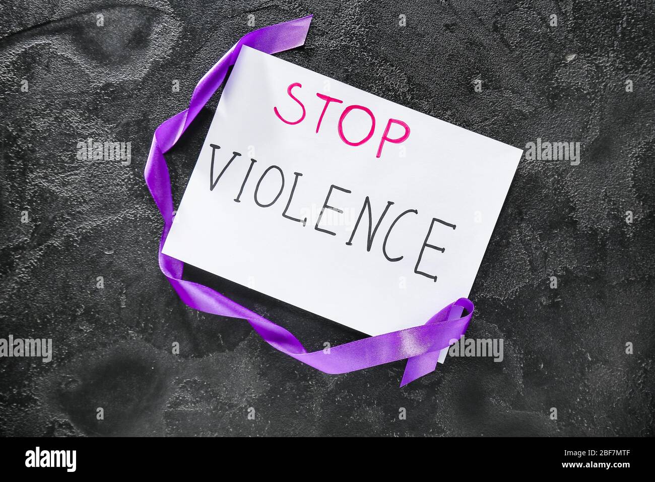Violet ribbon and text STOP VIOLENCE on dark background Stock Photo - Alamy