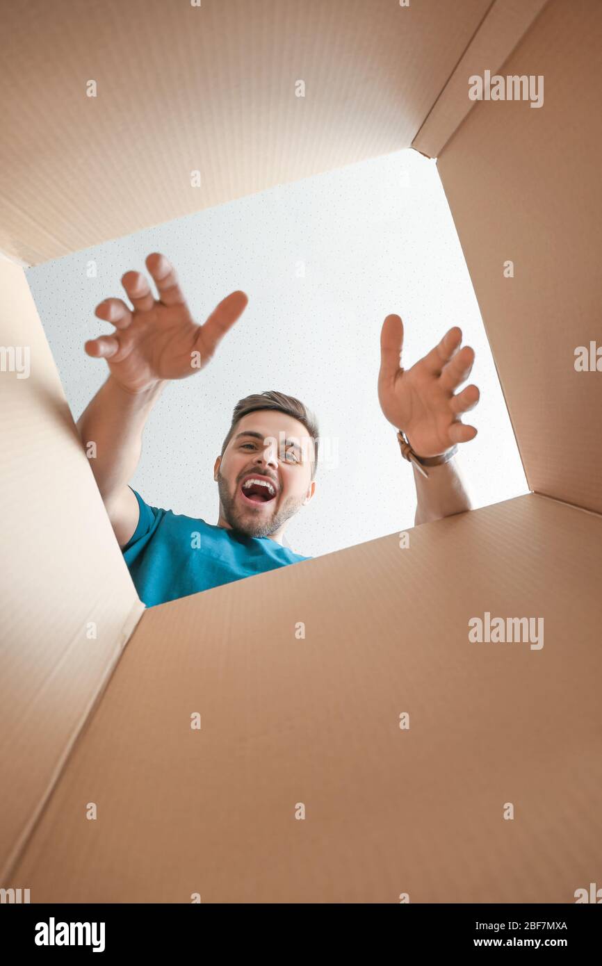 Happy man with open box, view from inside Stock Photo - Alamy