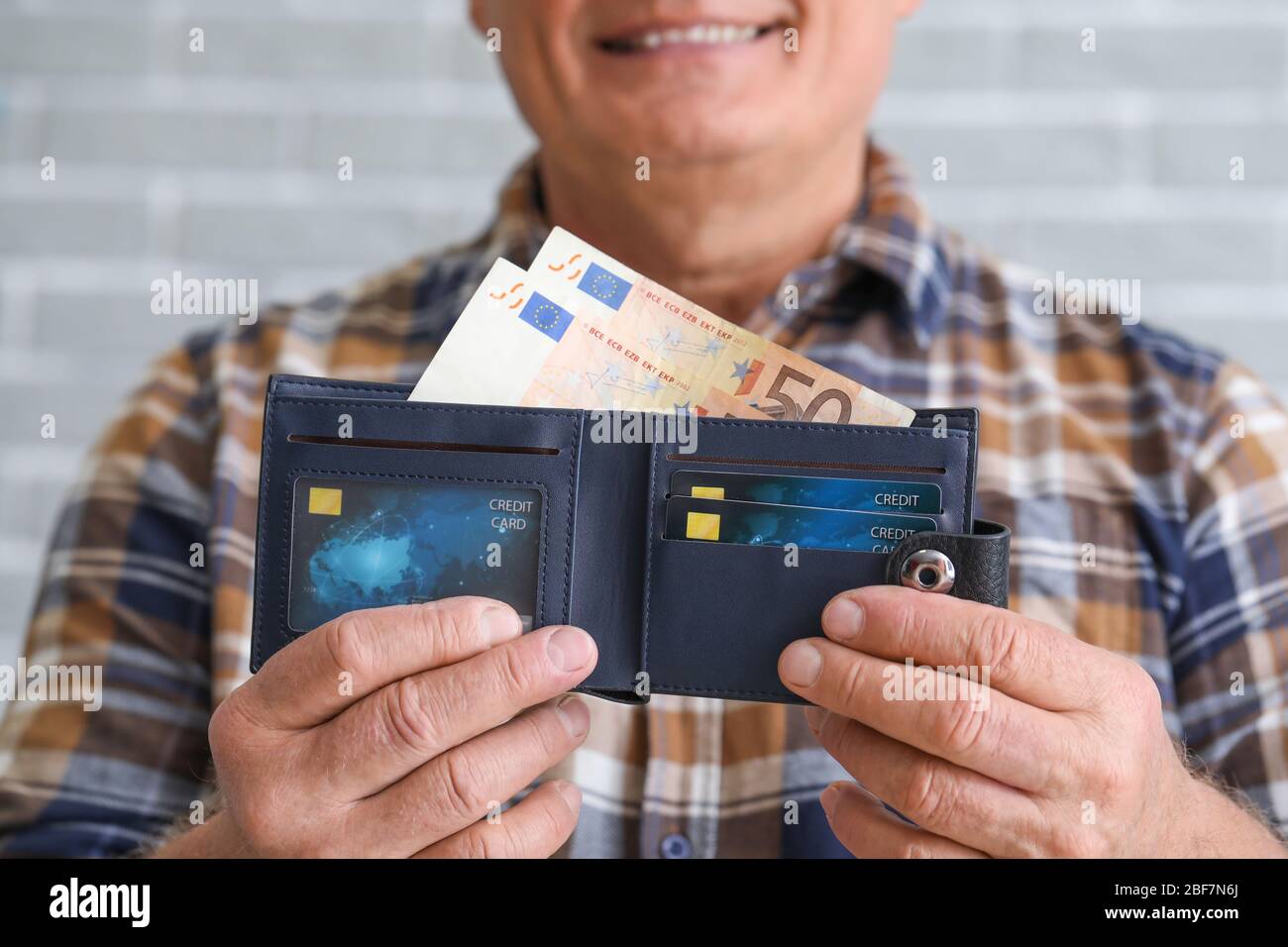 Senior man with purse on brick background, closeup Stock Photo - Alamy