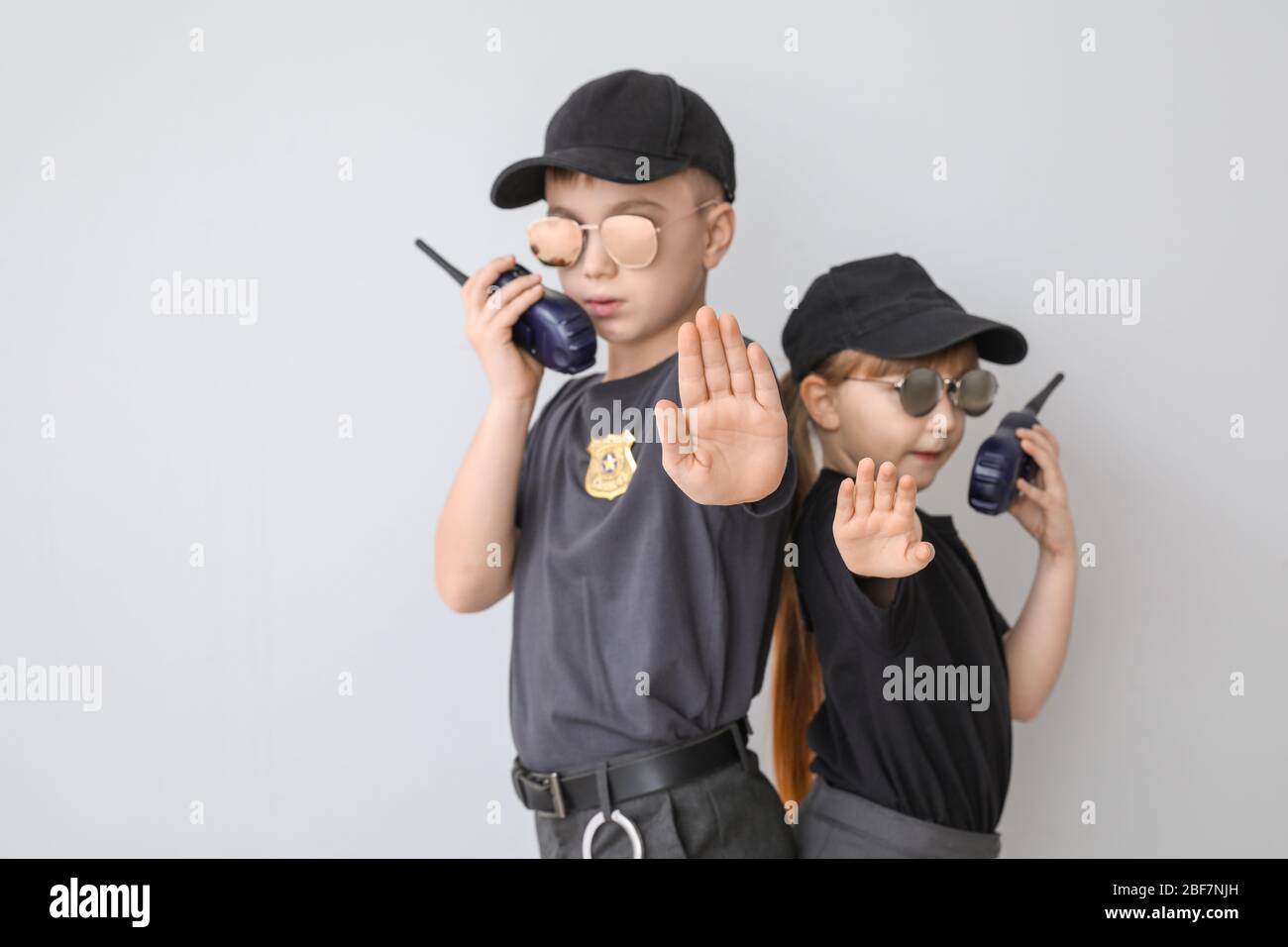 Cute little police officers on light background Stock Photo - Alamy