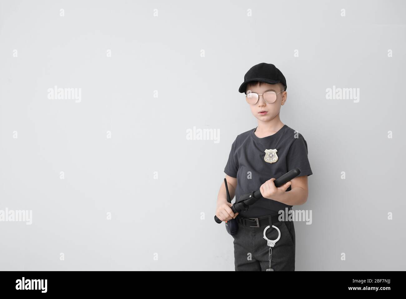 Cute little police officer on light background Stock Photo - Alamy
