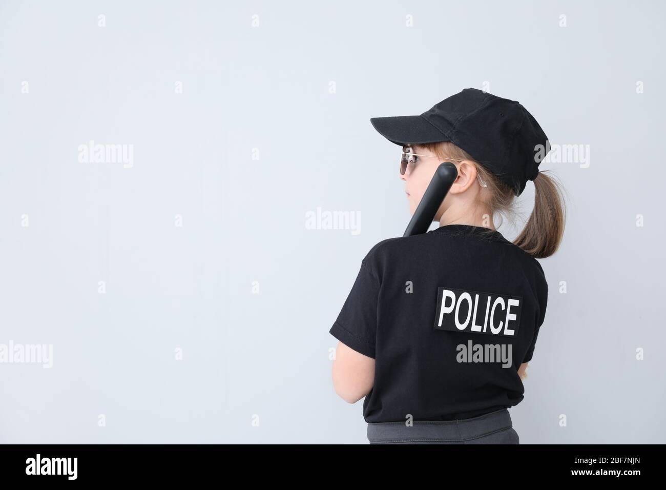 Cute little police officer on light background Stock Photo - Alamy