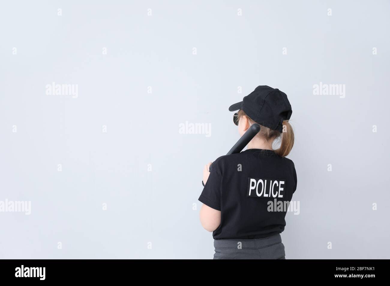 Cute little police officer on light background Stock Photo - Alamy