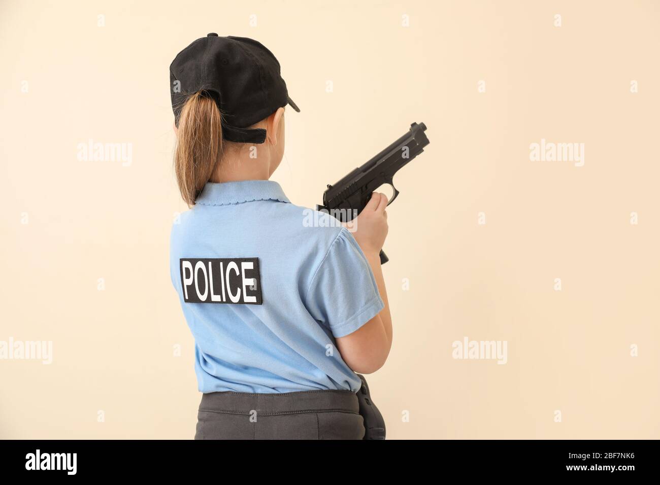 Cute little police officer on color background, back view Stock Photo ...