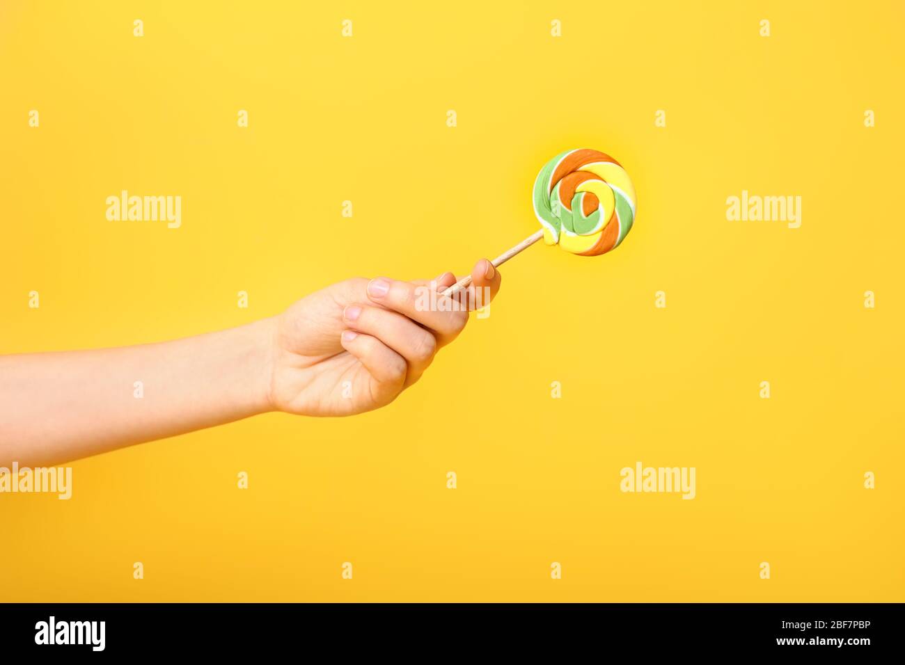 Female hand with sweet lollipop on color background Stock Photo - Alamy