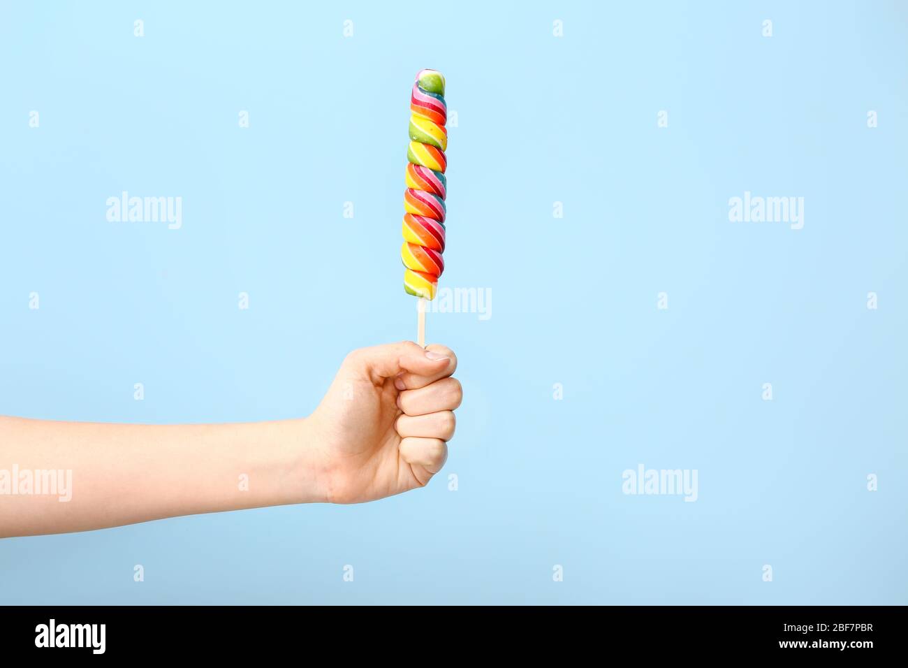 Female hand with sweet lollipop on color background Stock Photo - Alamy