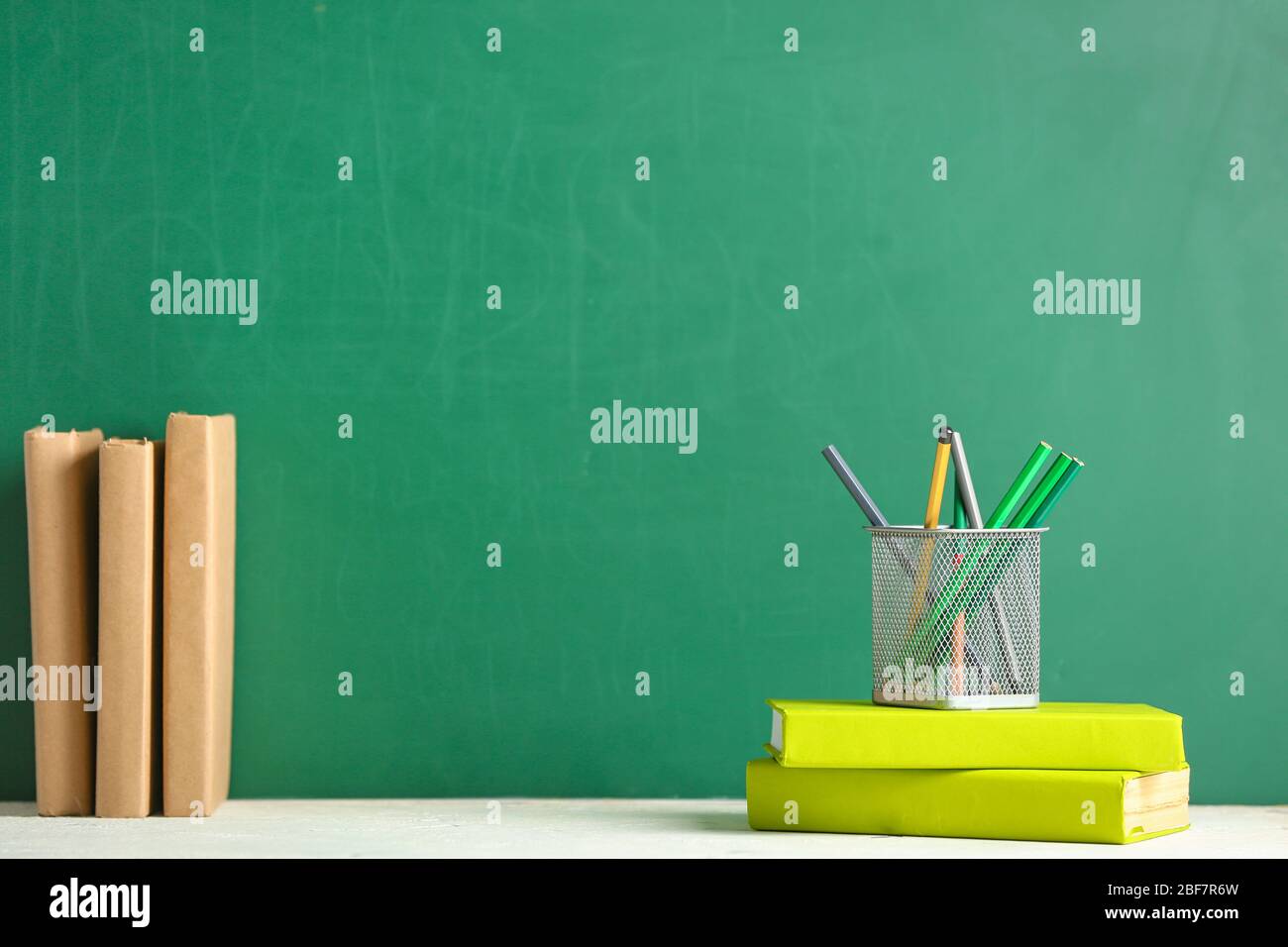 Books and stationery on table in classroom Stock Photo - Alamy