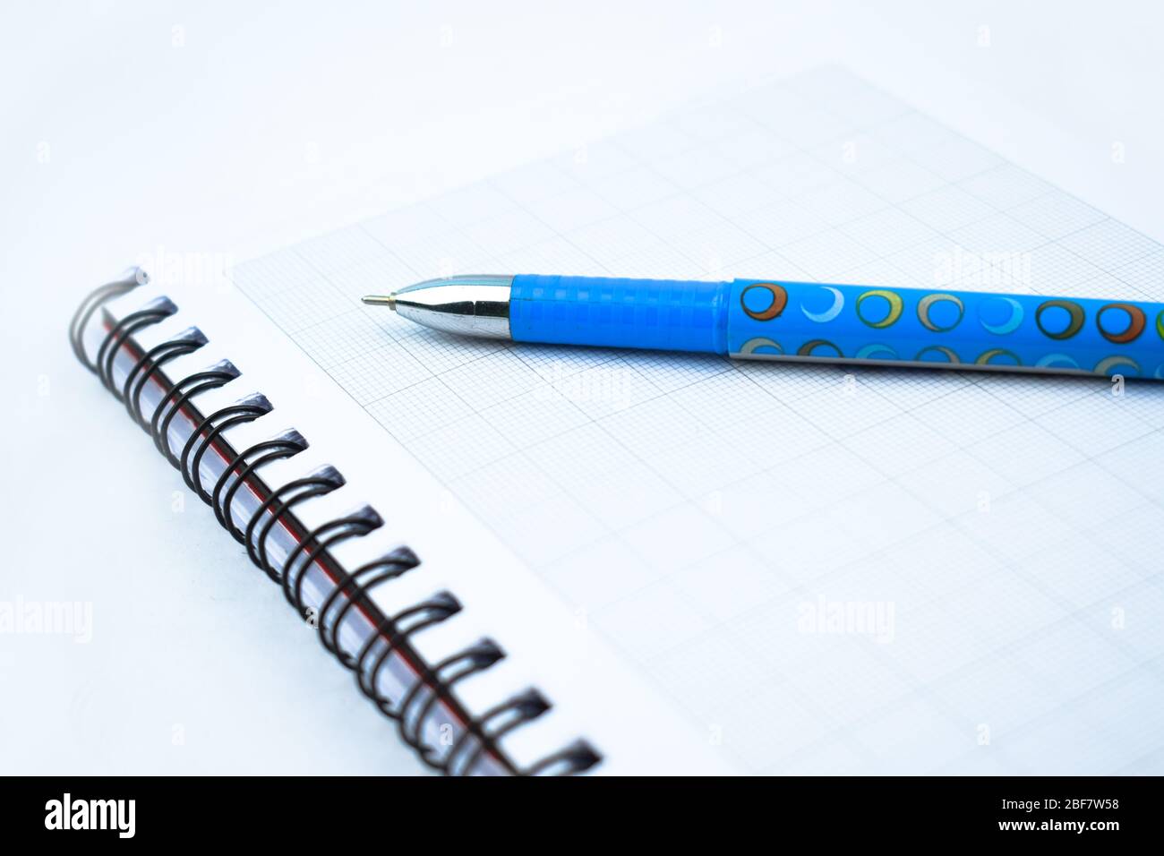 Side view of a light blue colored pen placed on top of a very simple ...