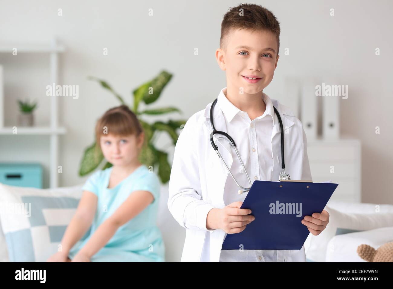 Cute little doctor with patient in clinic Stock Photo - Alamy