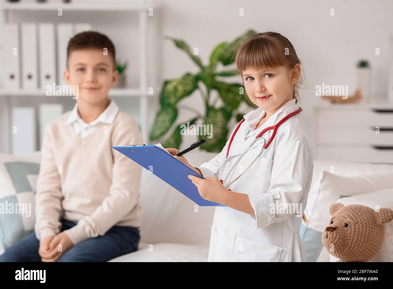 Cute little doctor with patient in clinic Stock Photo - Alamy