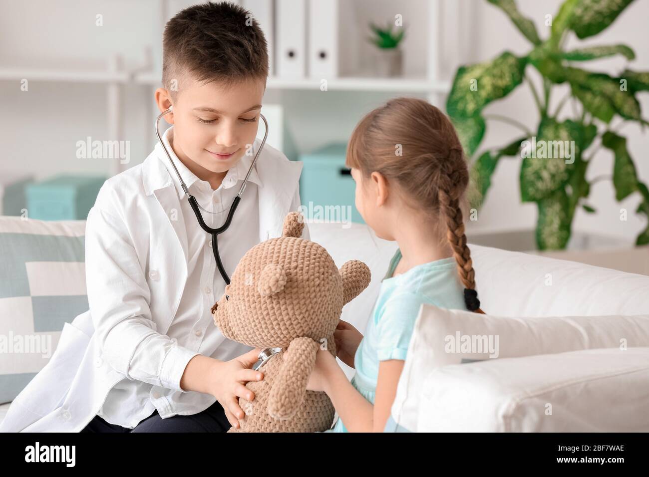 Cute little doctor working with patient in clinic Stock Photo - Alamy