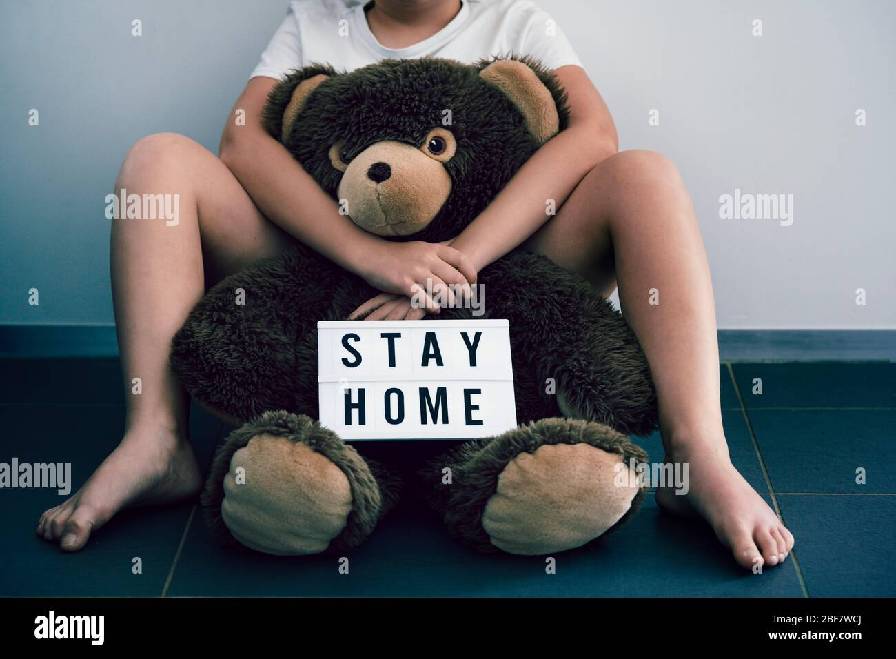 Boy with teddy bear and stay home words Stock Photo - Alamy