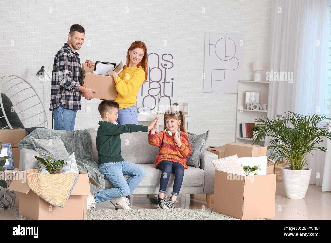 Family with moving boxes in their new house Stock Photo - Alamy