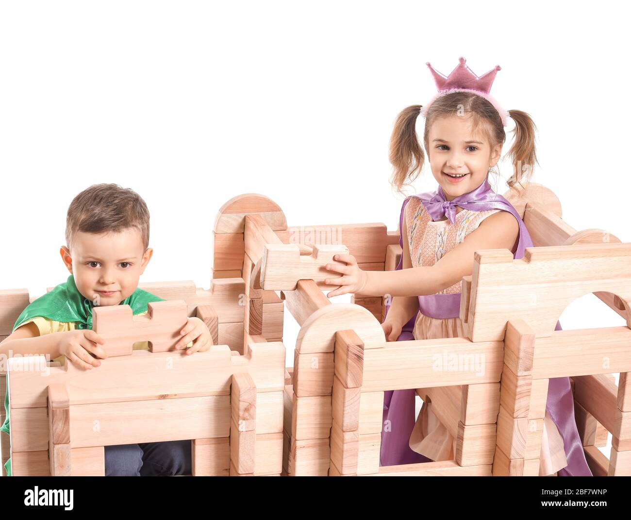 Little children in costumes playing with take-apart playhouse on white ...