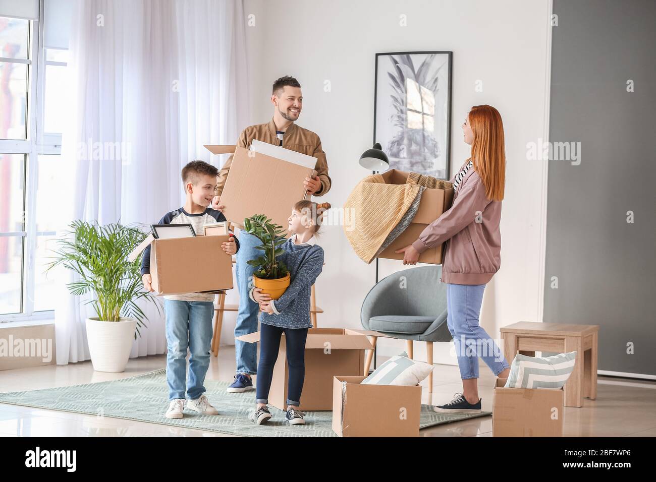 Family with moving boxes in their new house Stock Photo - Alamy