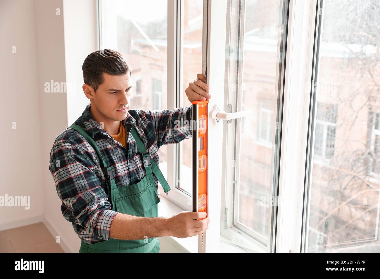 Male worker installing window in flat Stock Photo - Alamy