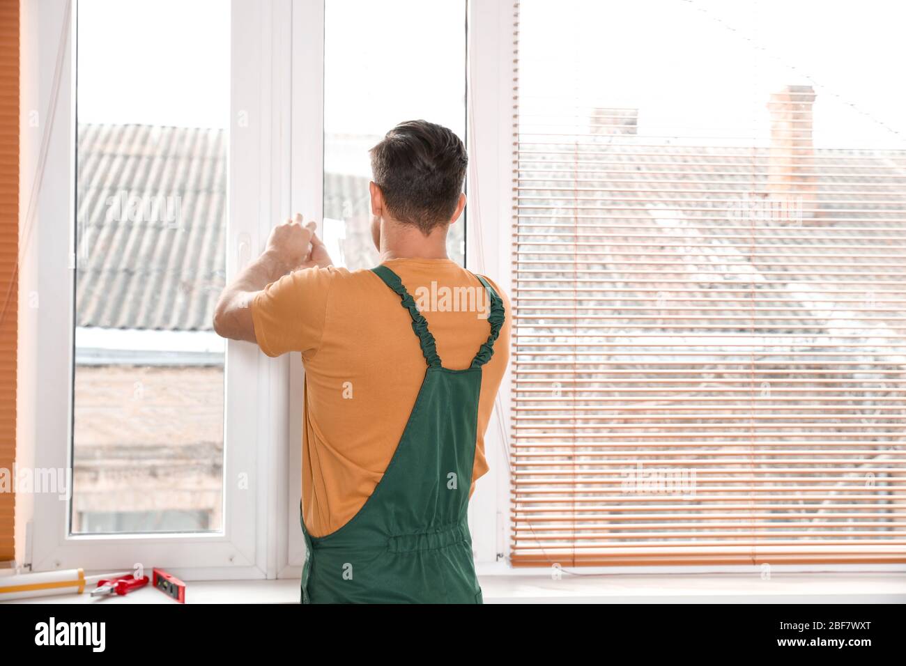 Male worker installing window in flat Stock Photo - Alamy