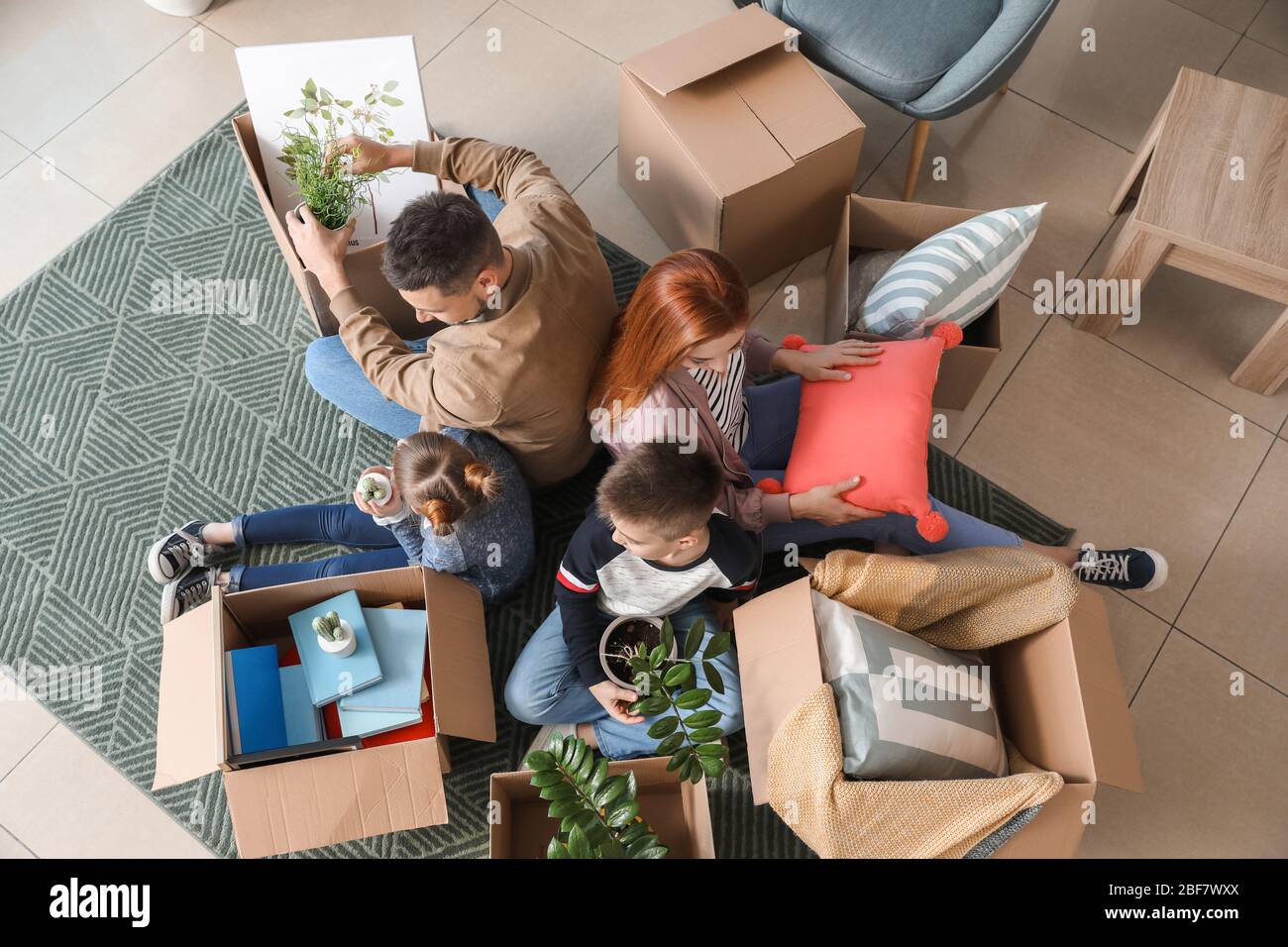 Family unpacking moving boxes in their new house, top view Stock Photo ...