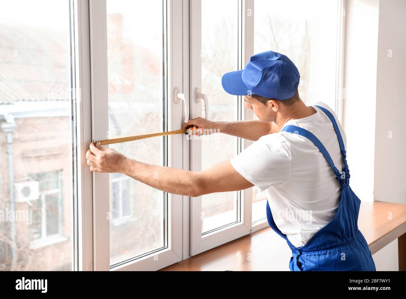 Male worker installing window in flat Stock Photo - Alamy