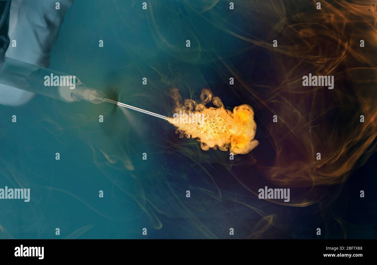 The needle of a syringe pierces a wall and vaccine or drugs like fire ...