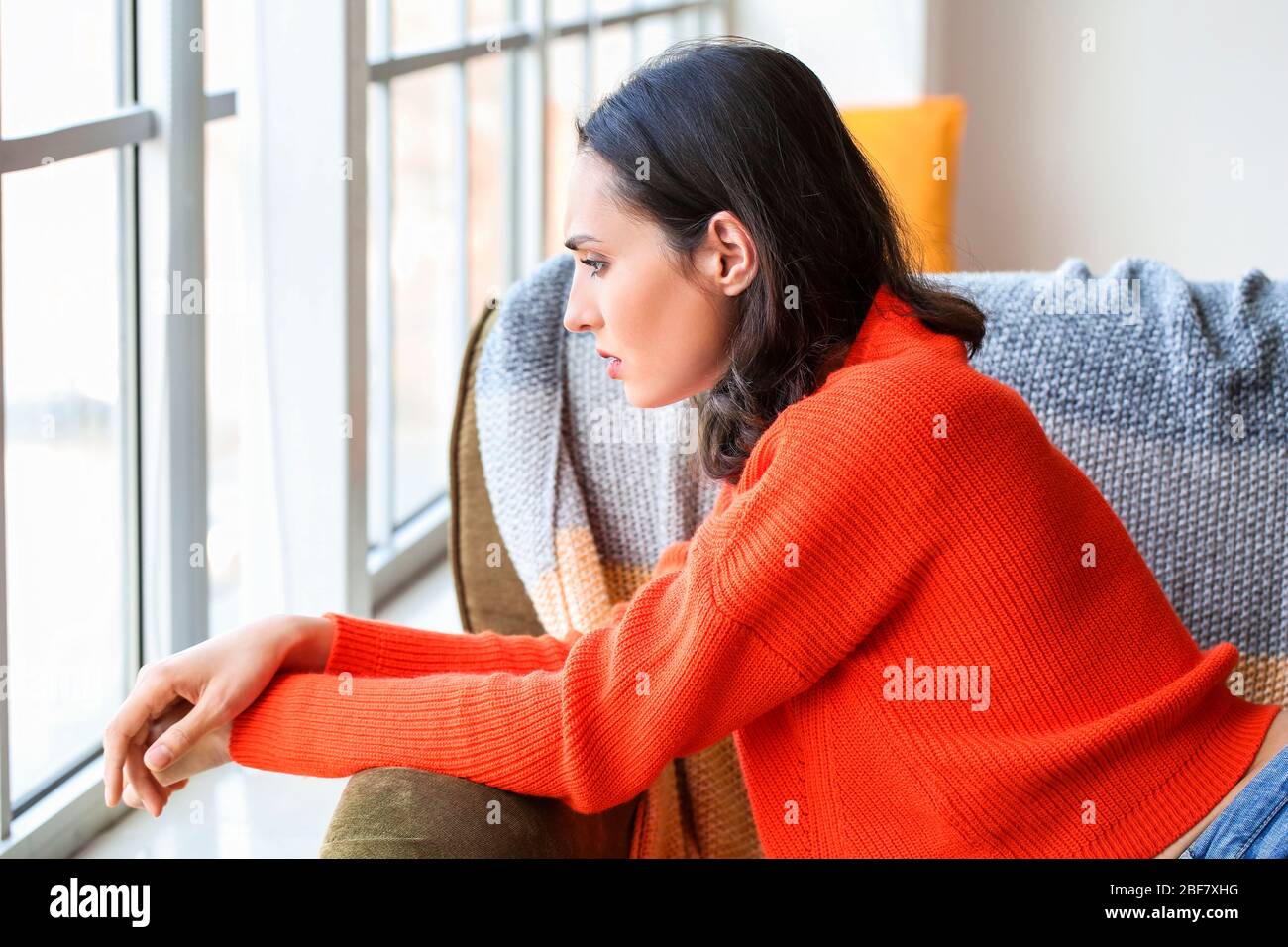 Depressed young woman near window Stock Photo - Alamy