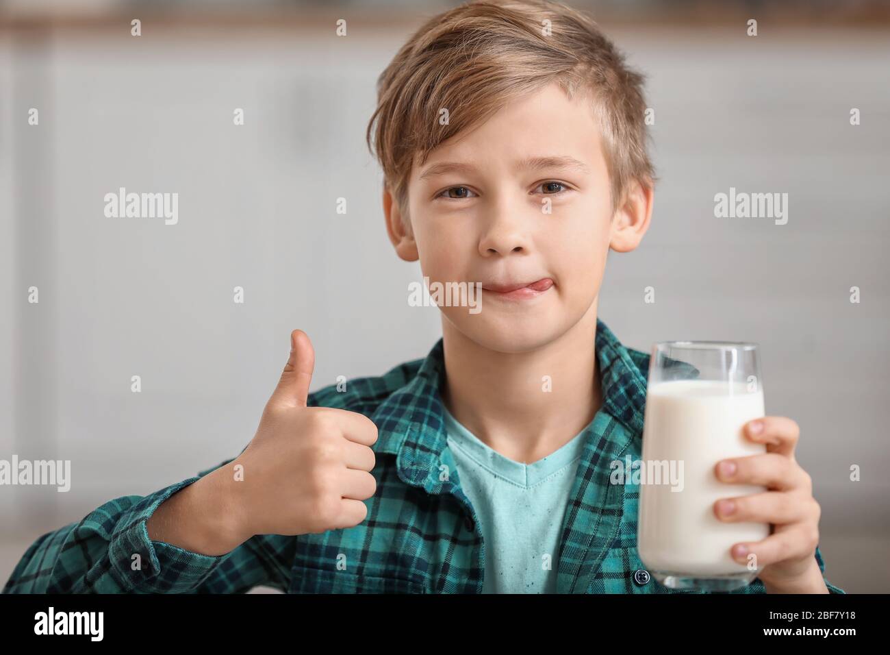 Little boy with milk showing thumb-up in kitchen Stock Photo - Alamy
