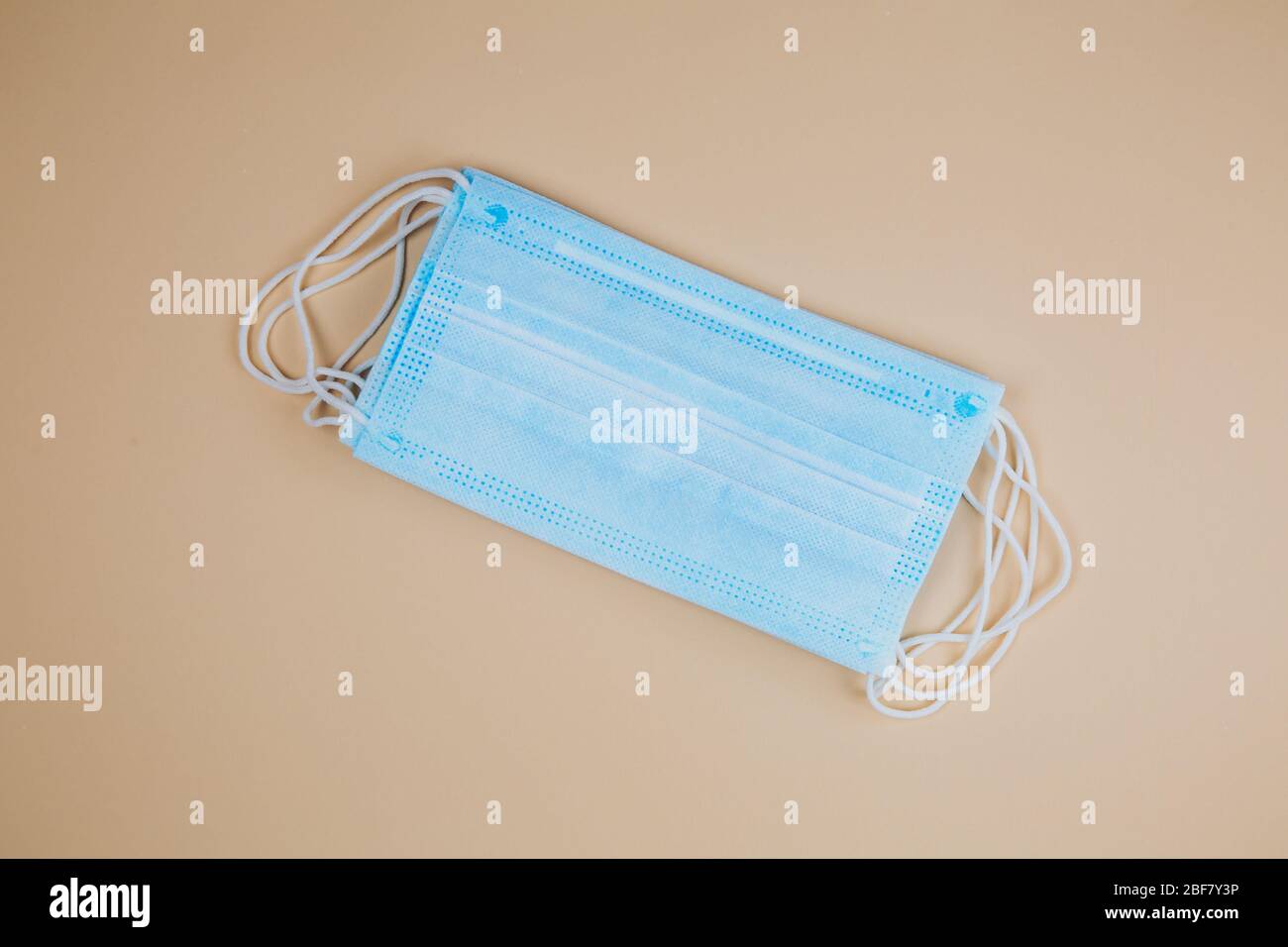Medical protective mask on a beige background. A disposable surgical ...