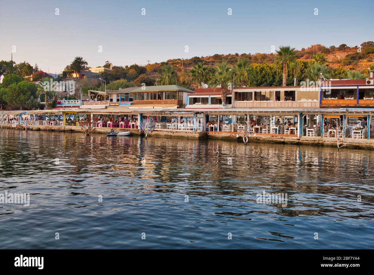 Restaurant and bougainvillea flowers on beach in Gumusluk, Bodrum ...