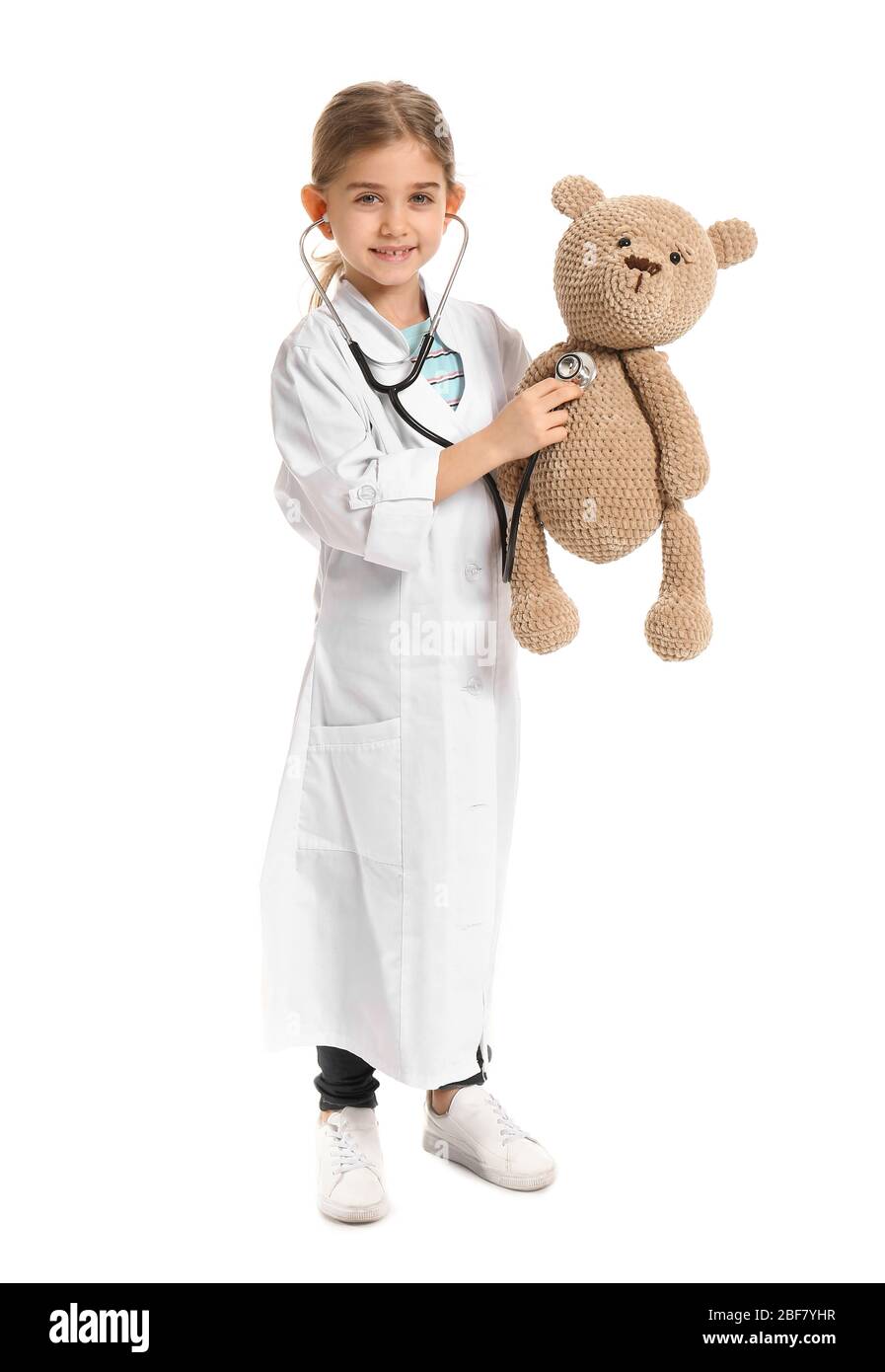 Cute little doctor with toy on white background Stock Photo - Alamy
