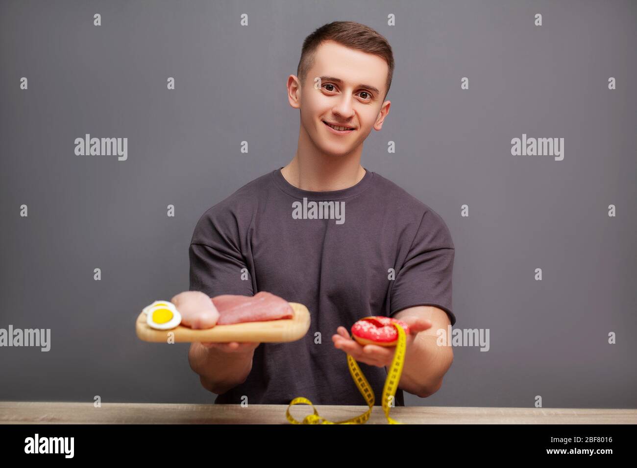 Strong man consumes a high-protein meal of meat and donut Stock Photo ...